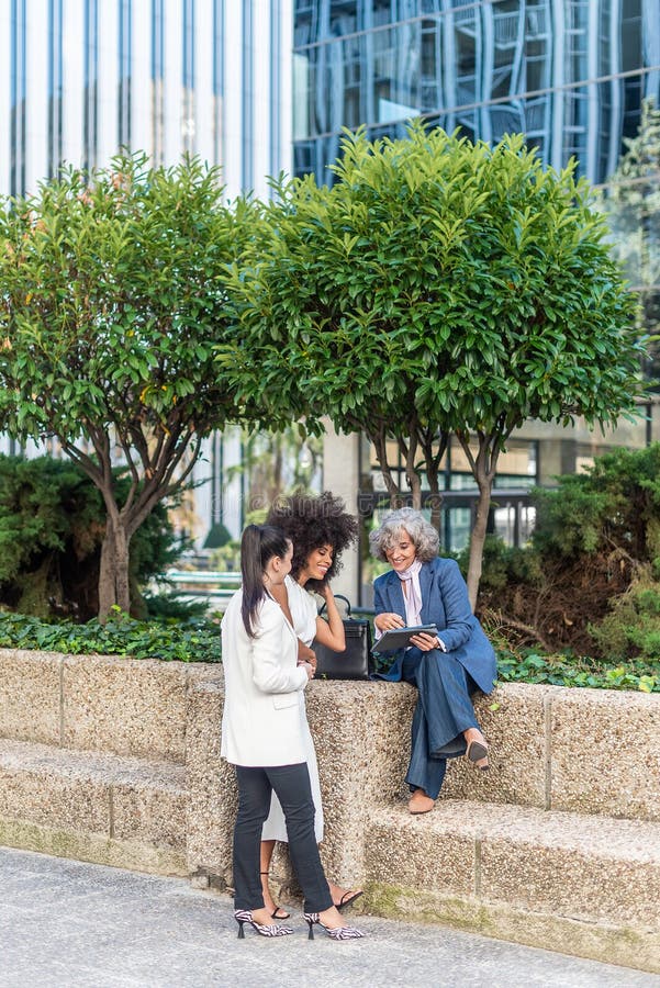 Three Co-workers Resting Together Surrounded by Skyscrapers Stock Photo ...