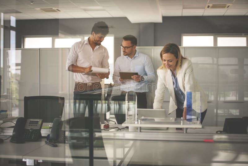 Three Colleague in Office Using Computer and Checking Document. Stock ...