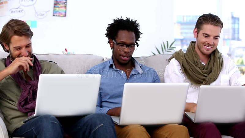 Three Colleagues Engaged in Collaborative Discussion Using Laptop Stock ...