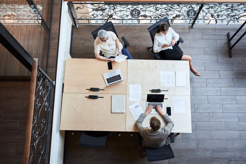 Three Colleagues Working at the Same Desk Stock Photo - Image of ...