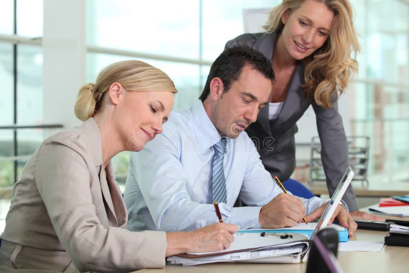 Three Colleagues Working Together Stock Image - Image of pens, comrade ...