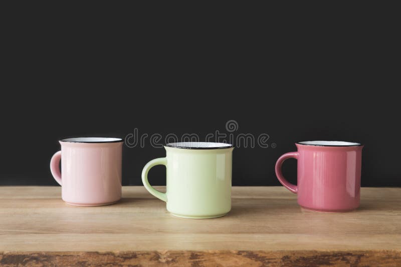 Three Colored Cups on Wooden Table on Black Stock Image - Image of ...