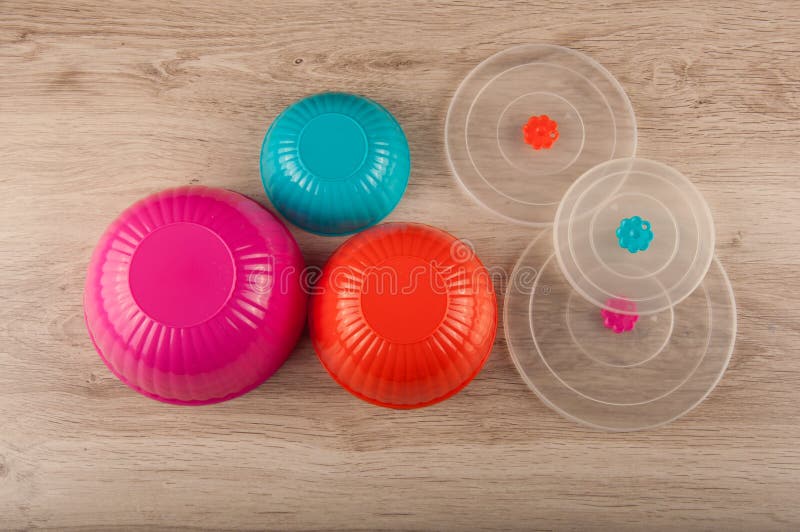 Three Colored Food Containers and Covers on Wooden Table Stock Photo ...