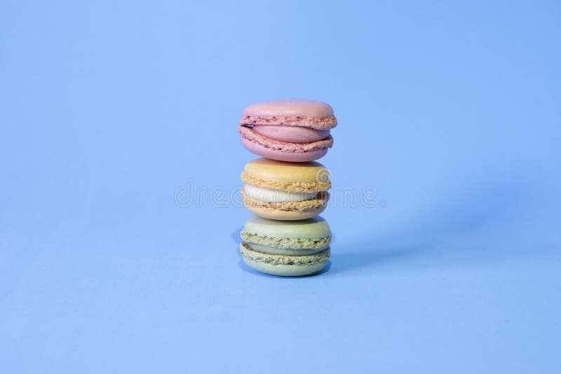 Three Coloured Macarons on a Blue Background Stock Photo - Image of ...