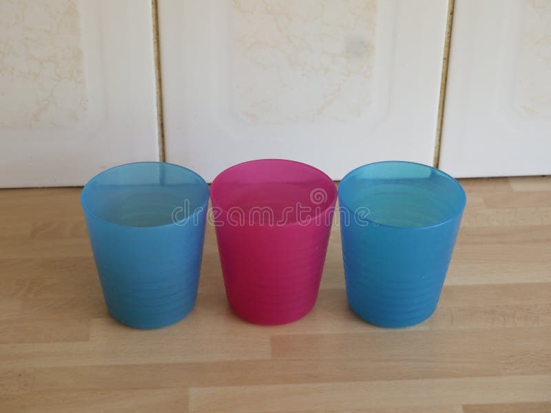 Three Colourful Plastic Beakers on a Wooden Kitchen Worktop Stock Photo ...