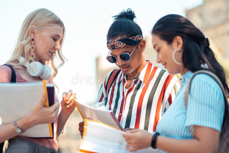Three Concentrated Students Discussing Their Term Papers. Stock Photo ...