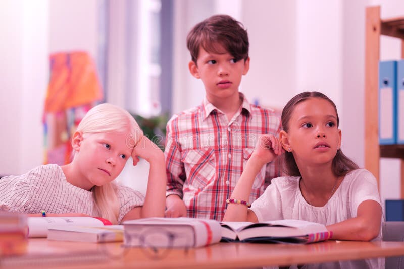 Three Confused Pupils Listening To Their Teacher. Stock Photo - Image ...