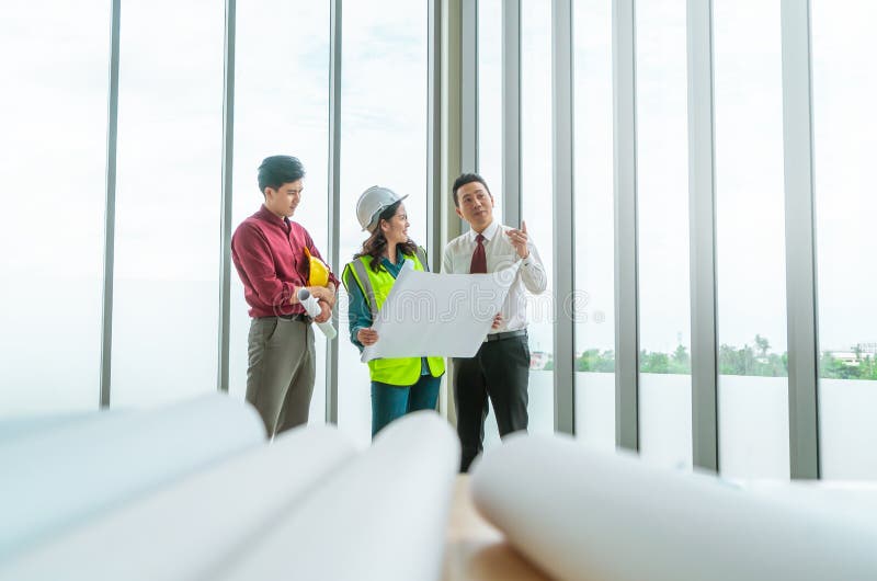 Three Construction Builder Team Looking at Building and Design in ...