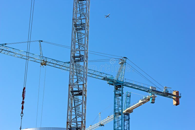 Three Construction Cranes Work a Side by Side. Stock Photo - Image of ...