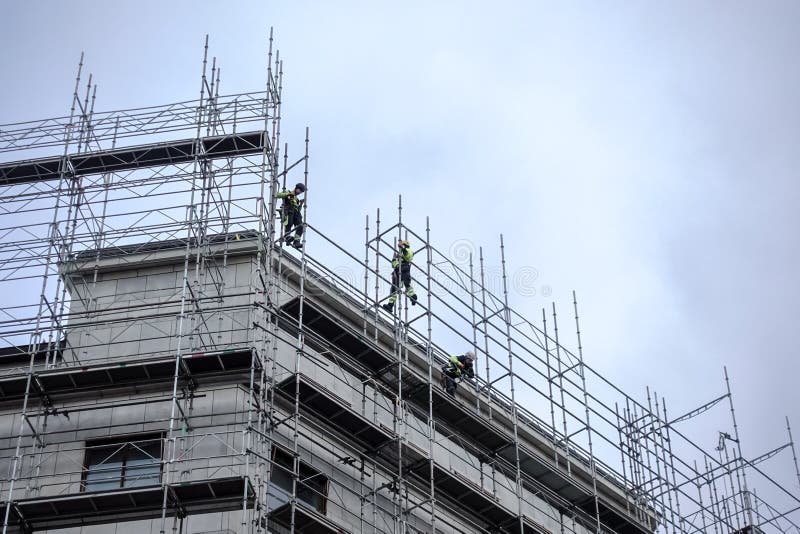 Construction Workers on Scaffolding High Up on Commercial Building ...
