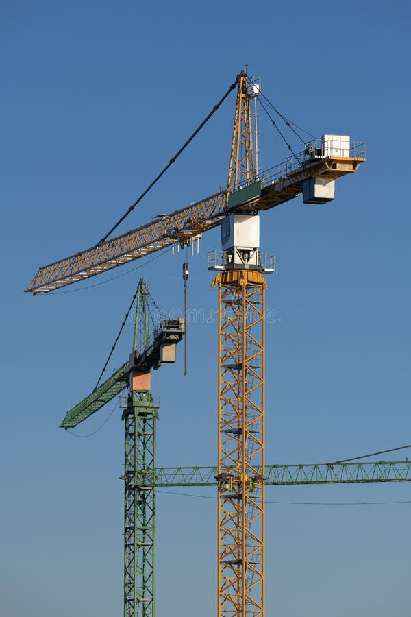 Three Cranes in the Evening Light on a Large Construction Site in the ...