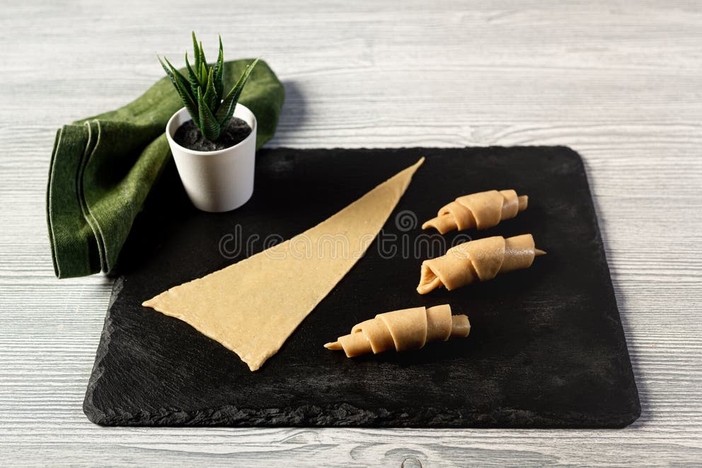 Three Croissant-shaped Rolls, Uncooked, with the Triangle Shaped Piece ...