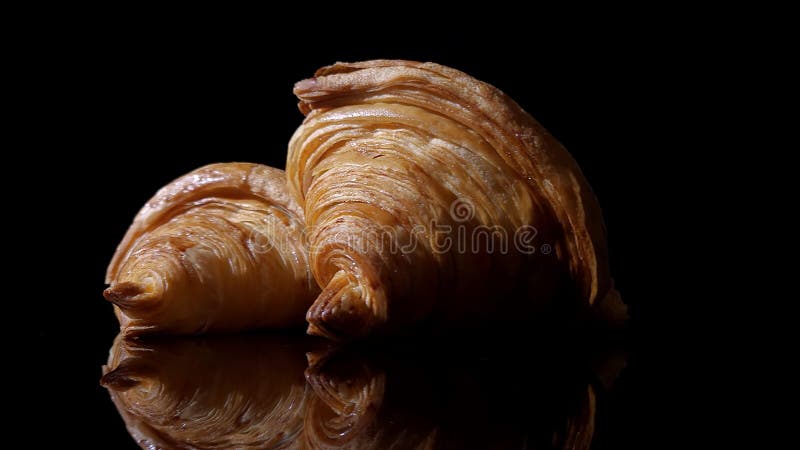 Three Croissants Rotating Counter Clockwise on a Black Reflective ...