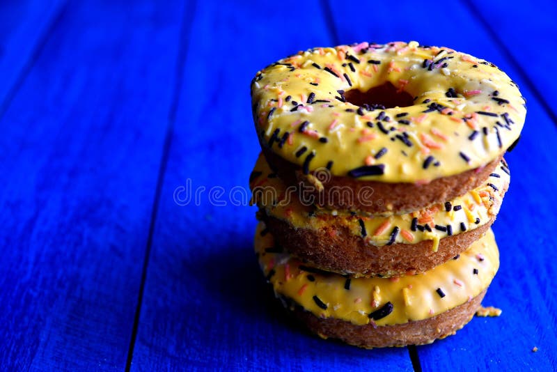 Three Delicious Donuts Folded in a Pyramid on a Table of Painted Blue ...