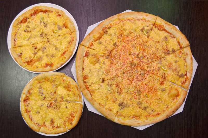 Three Delicious Fresh Cheese Pizzas with Fish, Lemon on Black Table ...