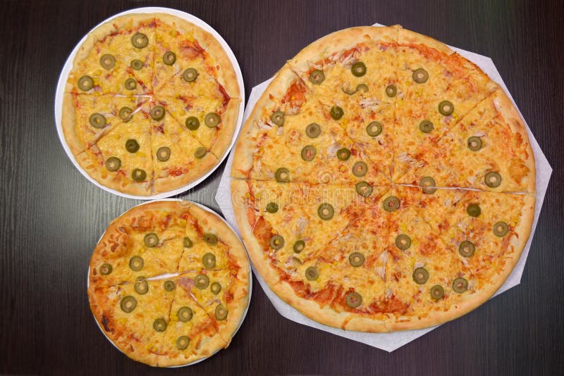 Three Delicious Fresh Cheese Pizzas with Ham, Olives on Black Table ...