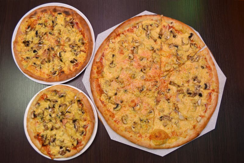 Three Delicious Fresh Cheese Pizzas with Mushrooms, Ham on Black Table ...