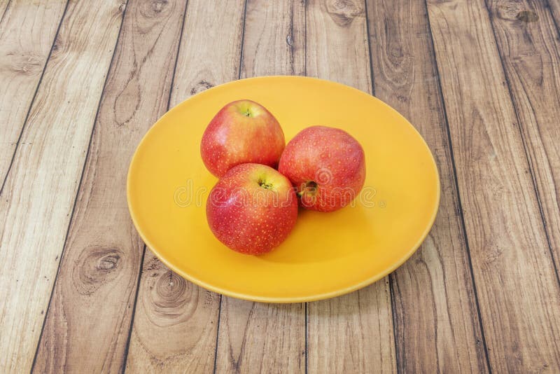 Three Delicious Royal Apples on a Yellow Plate Stock Photo - Image of ...