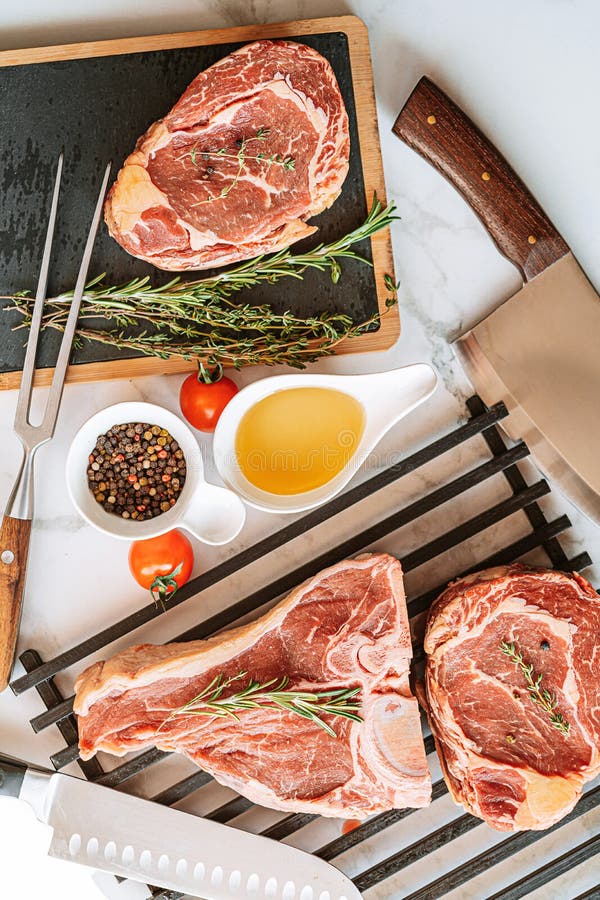 Three Delicious Steaks Ready To Grill on a White Marble Surface Stock ...