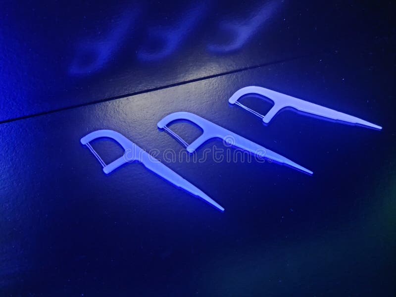 Three Dental Floss Tools Aligned in a Row, Captured Under Blue Lighting ...
