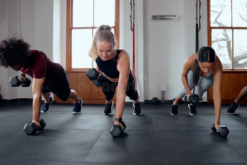 Three Determined Young Adults in a Row Doing Plank Exercises with ...
