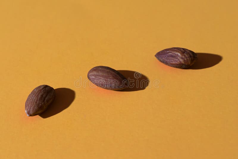 Three Different Almonds on an Orange Colored Background Stock Image ...