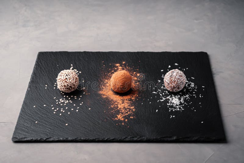 Three Different Date Candies with Coconut Carob and Sesame on a Slate ...