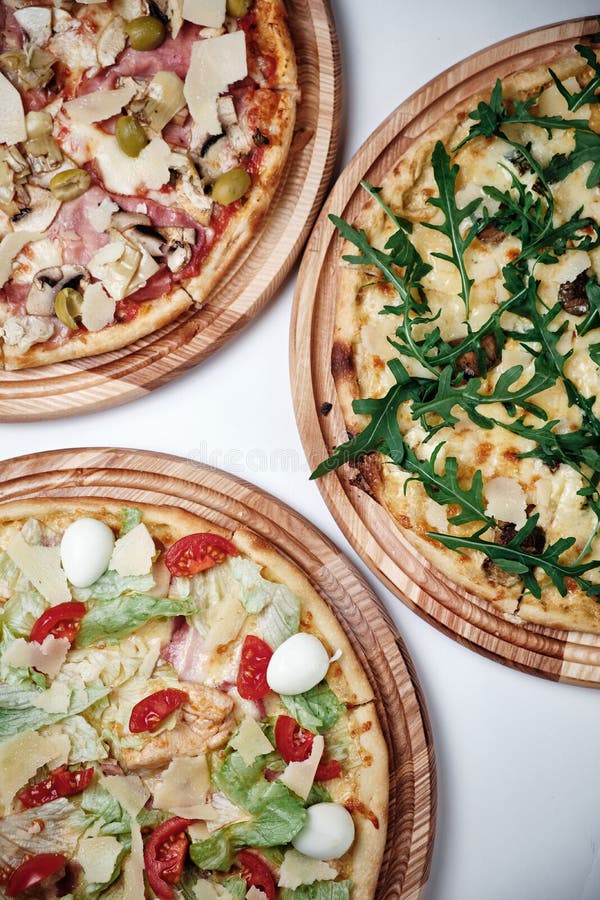 Three Different Pizza on Wooden Boards on a White Background Stock ...