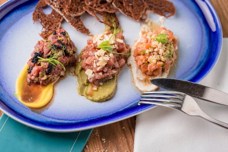 Three Different Tartars on a Blue Plate Stock Image - Image of dish ...