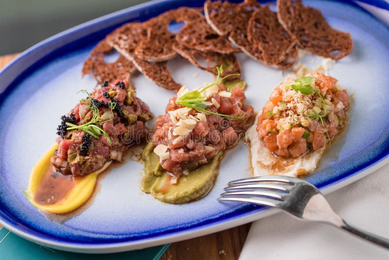 Three Different Tartars on a Blue Plate Stock Photo - Image of contrast ...