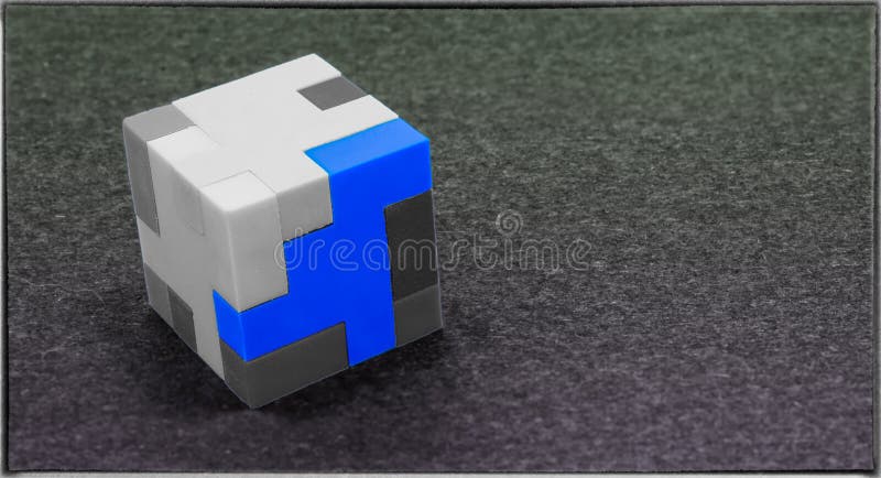 Three Dimensional White, Grey and Blue Cube Puzzle on a Grey Background ...