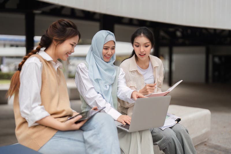 Diverse Female Students Collaborating on a Laptop Project in a Campus ...