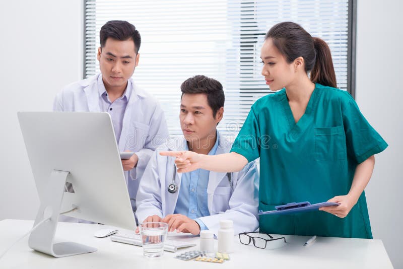 Three Doctors Discussing Patient Files on Office Stock Photo - Image of ...