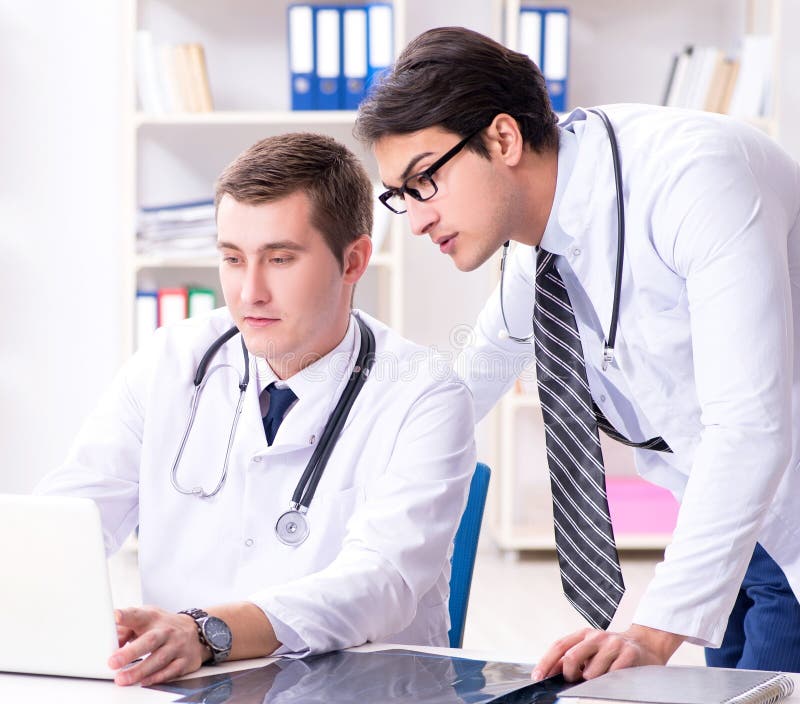 Three Doctors Discussing Scan Results of X-ray Image Stock Image ...