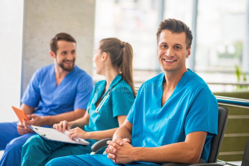 Three Doctors Sitting Together and Talking during Changeover Stock ...