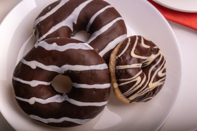 Three Donuts Glazed with Chocolate on the Table Stock Photo - Image of ...