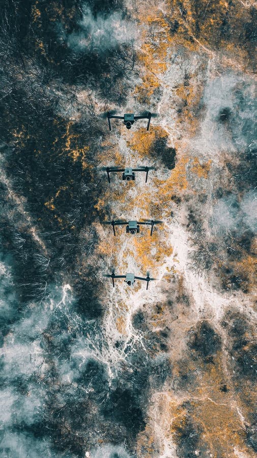 Three Drones Flying in Formation Over Rugged Terrain Stock Photo ...