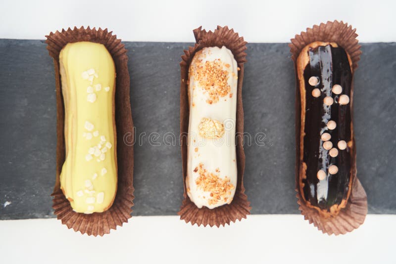 Three Eclairs on a Black Tray Top View Stock Image - Image of ...