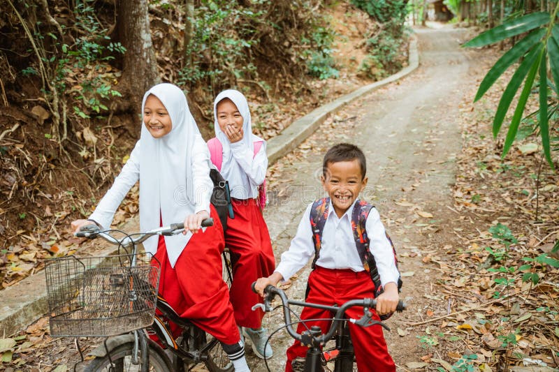 Three Elementary Students Riding Their Bike Together Stock Image ...
