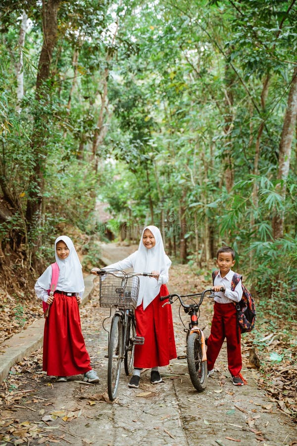 Three Elementary Students in Uniform Standing Together with a Lot of ...