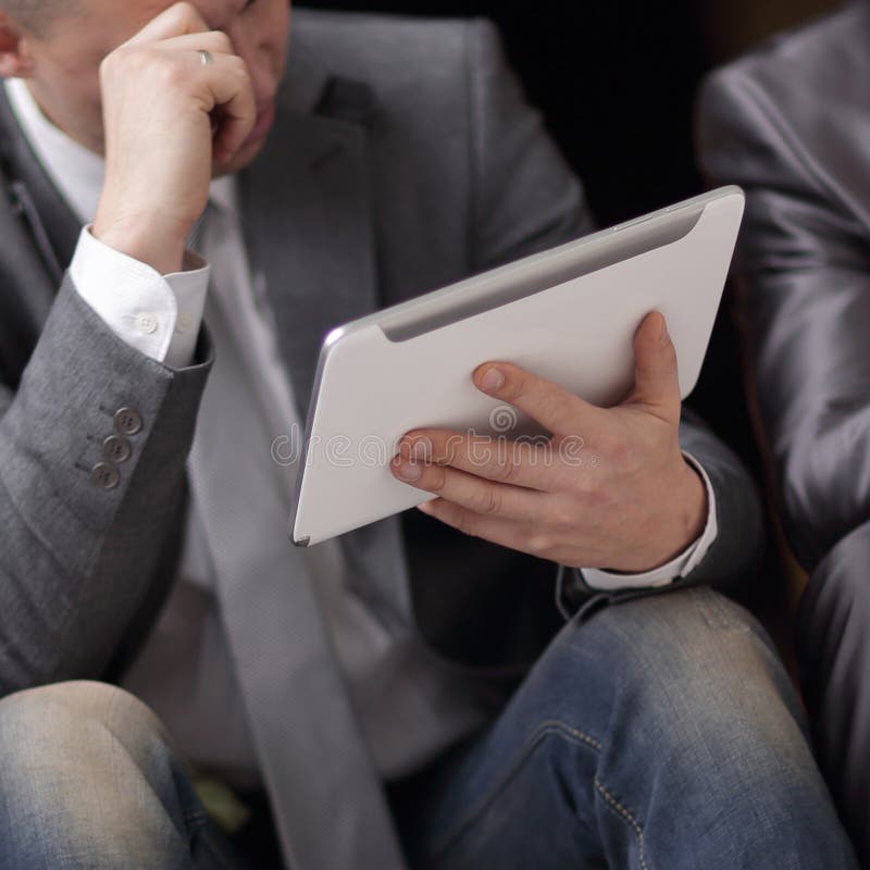 Three Employees with Digital Tablets Sitting on the Steps in the Office ...