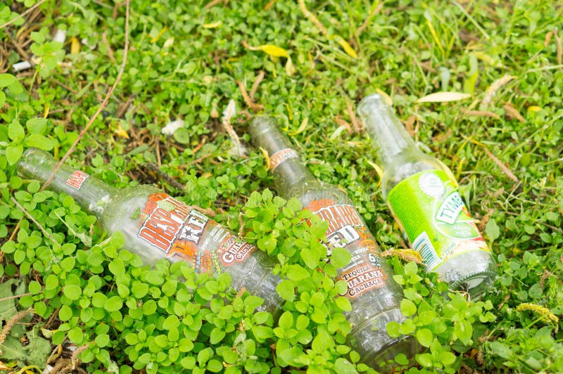 Empty Bottles on the Green Grass and Weed in the Park Editorial Photo ...