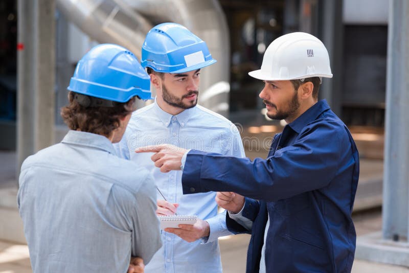 Three Engineer Talking about they Work at Construction Site Stock Photo ...