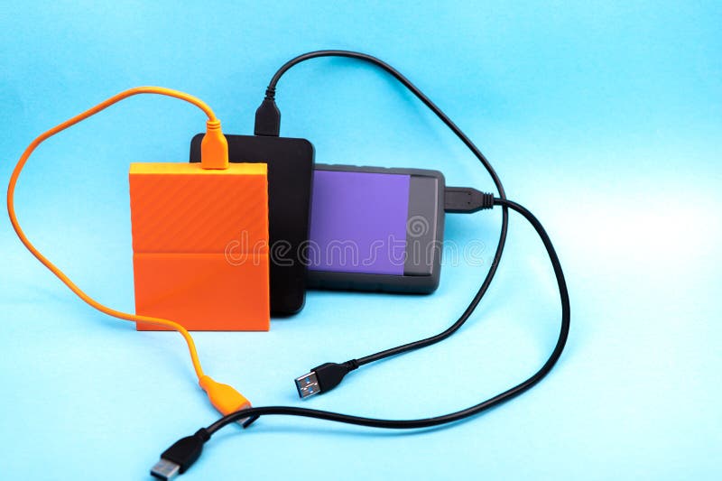 Three External Portable Hard Disk Drives Isolated on Light Blue Stock ...