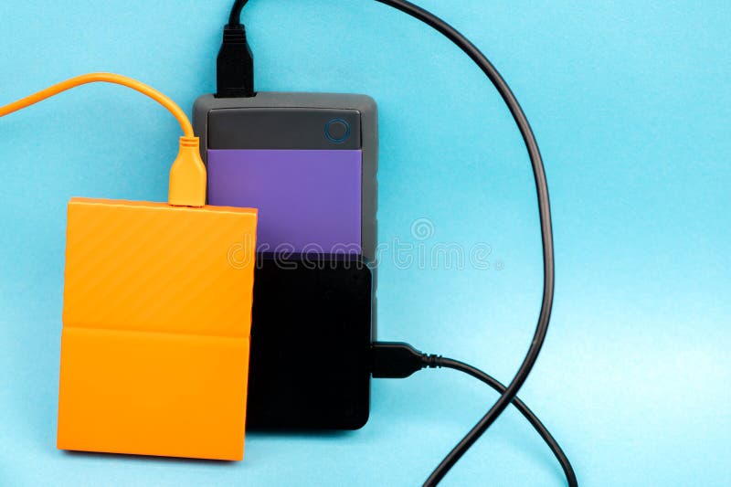 Three External Portable Hard Disk Drives Isolated on Light Blue Stock ...