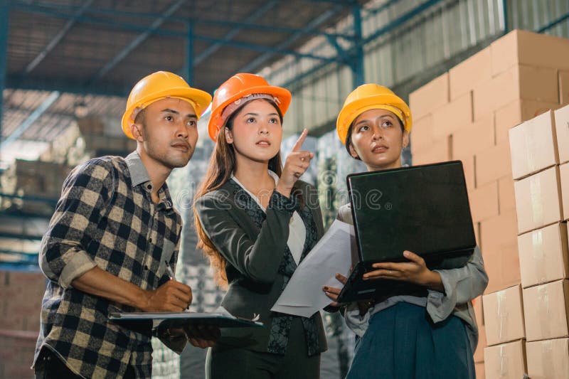 Three Factory Employees Observe the Production Process with a Laptop ...