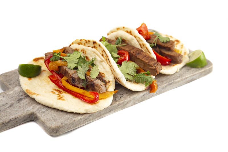 Three Fajitas on a Marble Serving Board on a White Background Stock ...
