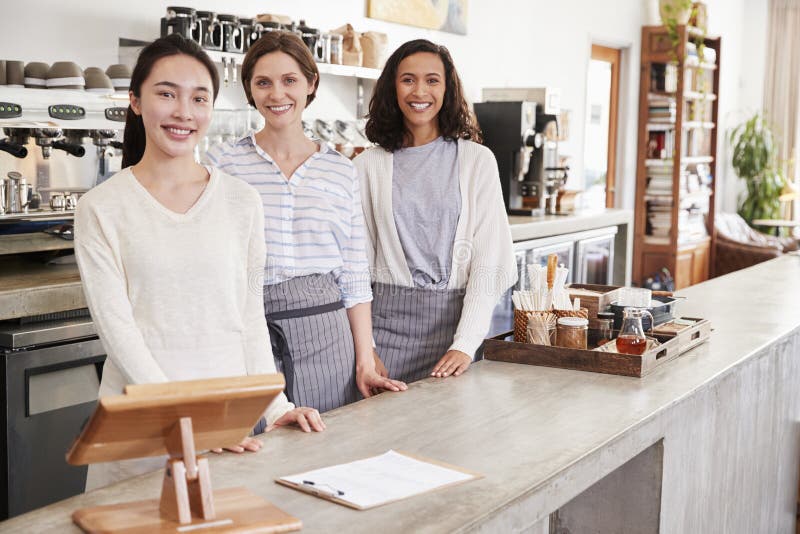 Three Female Coffee Shop Owners Standing Behind the Counter Stock Photo ...