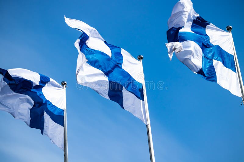 Three Finnish National Flags on the Wind Against the Blue Sky Stock ...