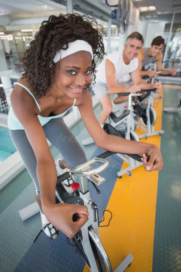 Three Fit People Working Out on Exercise Bikes Stock Photo - Image of ...